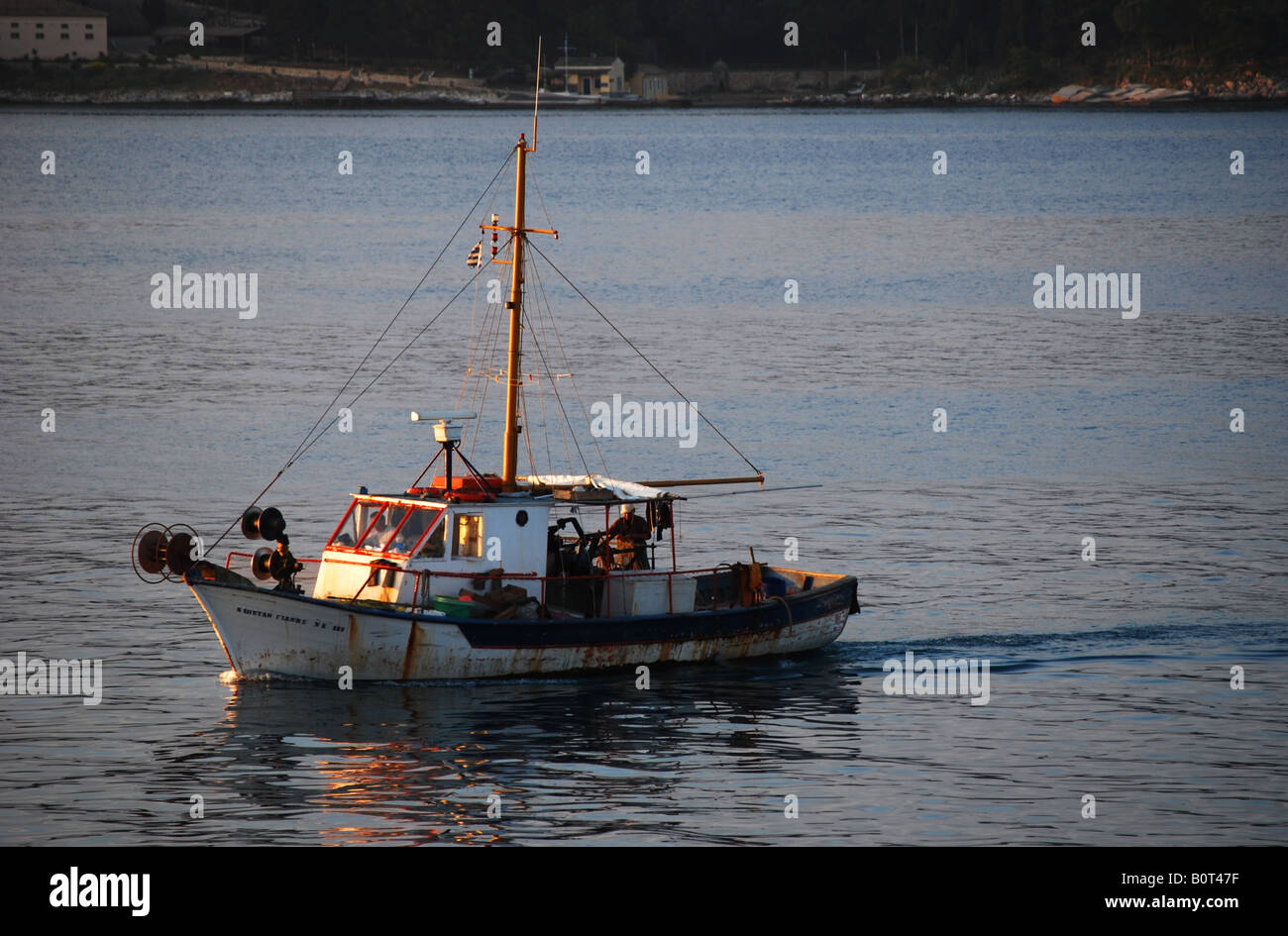 A fishing boat returning to the dock, late in the evening Stock Photo ...