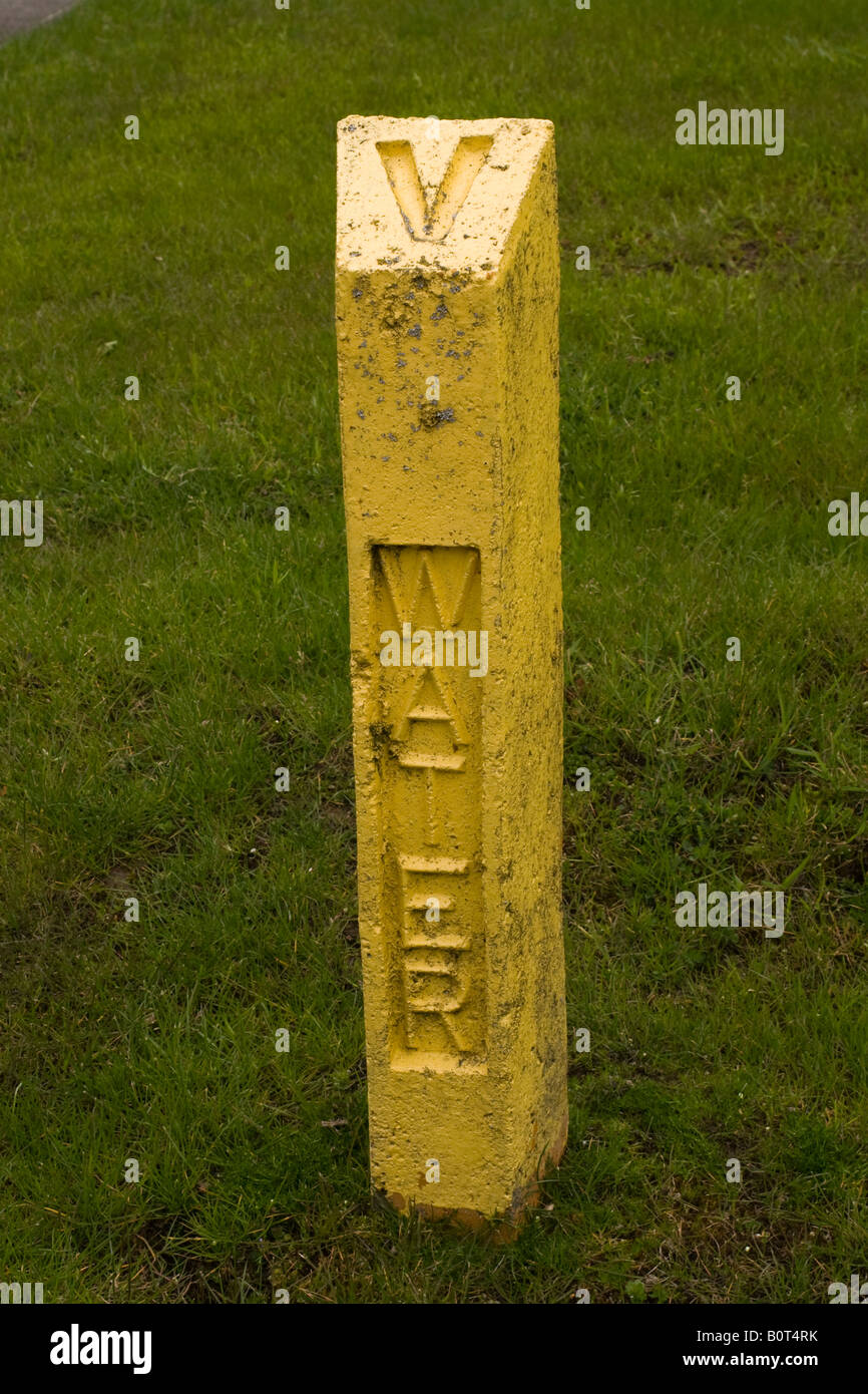Yellow metal municipal water marker Stock Photo - Alamy