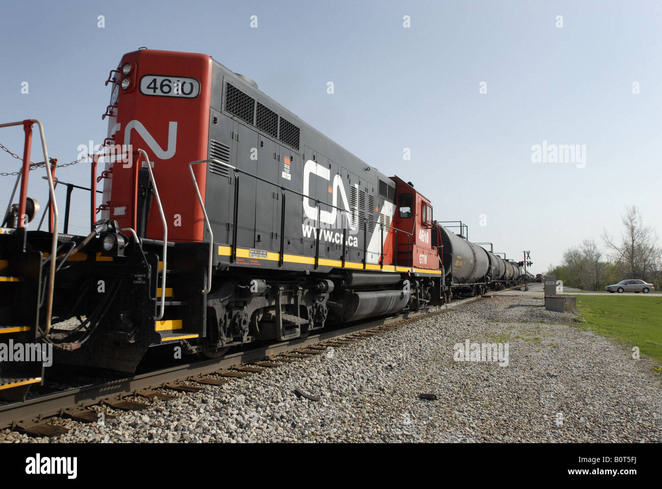A Canadian National freight train crosses a rural road in the ...