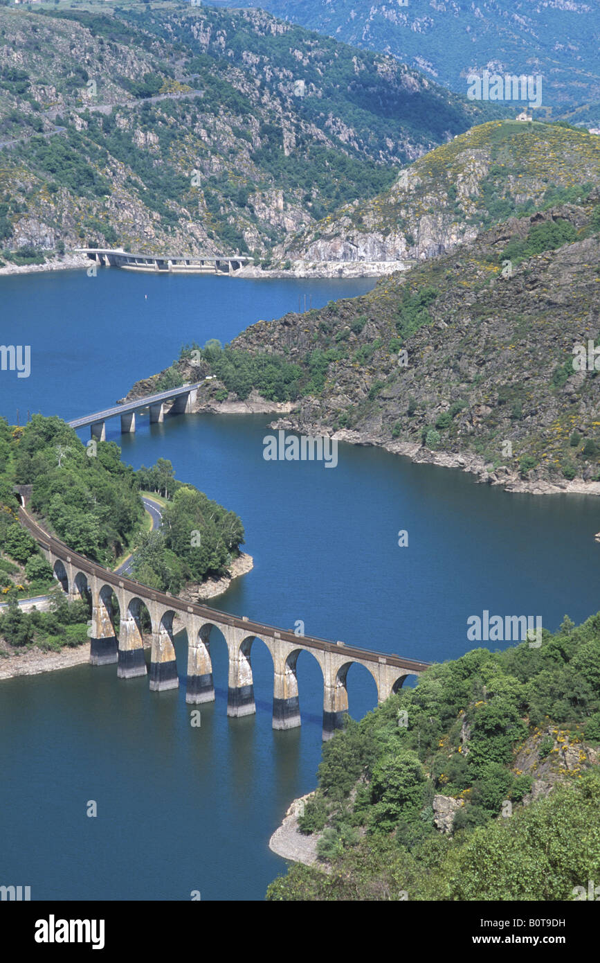A railroad bridge crosses the Lac de Villefort in the Lozere region of ...