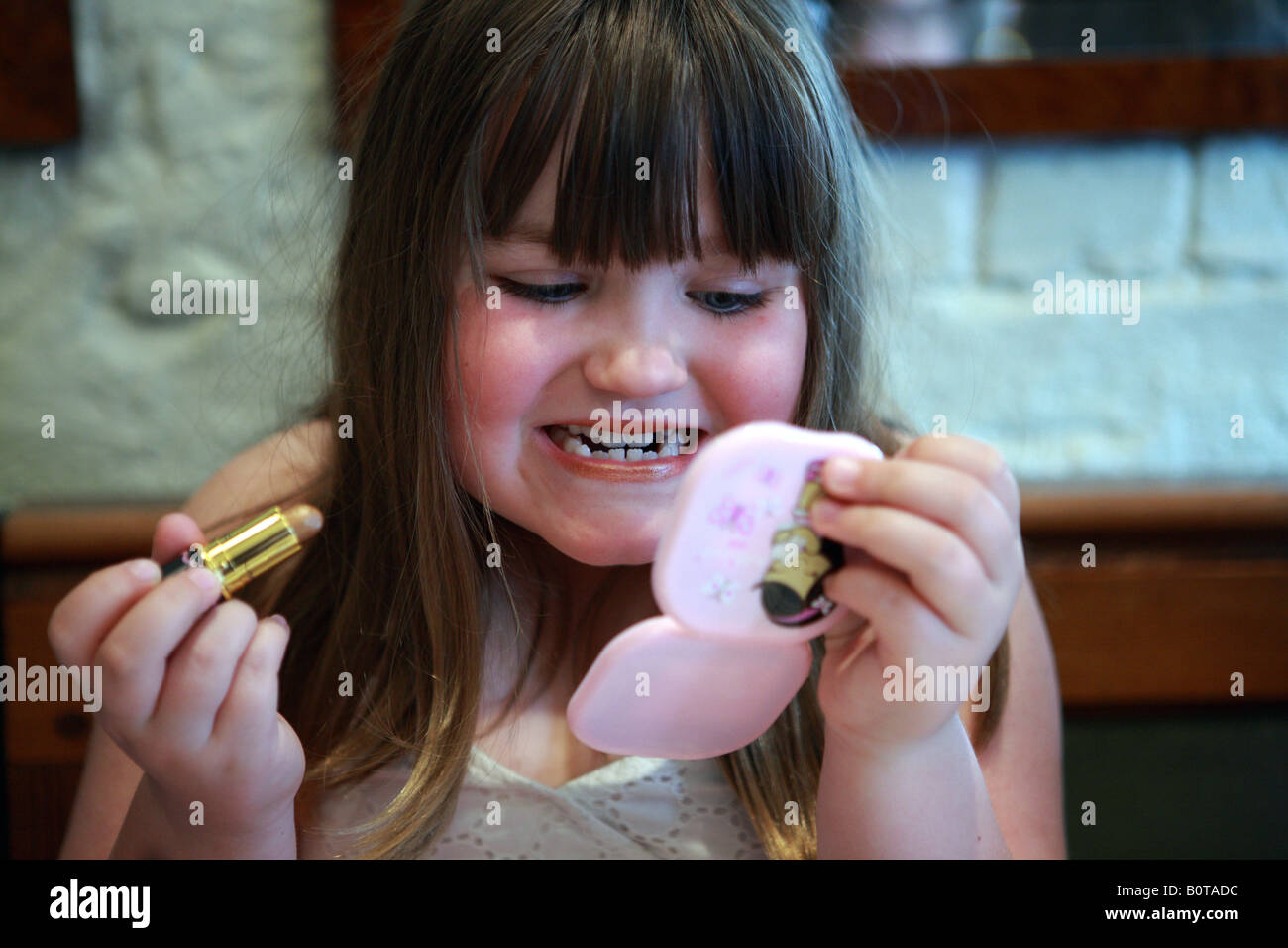 Seven year old girl, playing with make-up, at a busy restaurant Stock ...