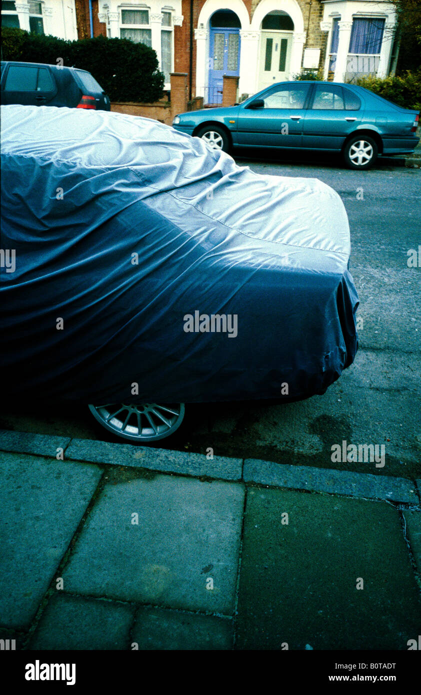 a tarpaulin covered car in a suburban london street Stock Photo - Alamy