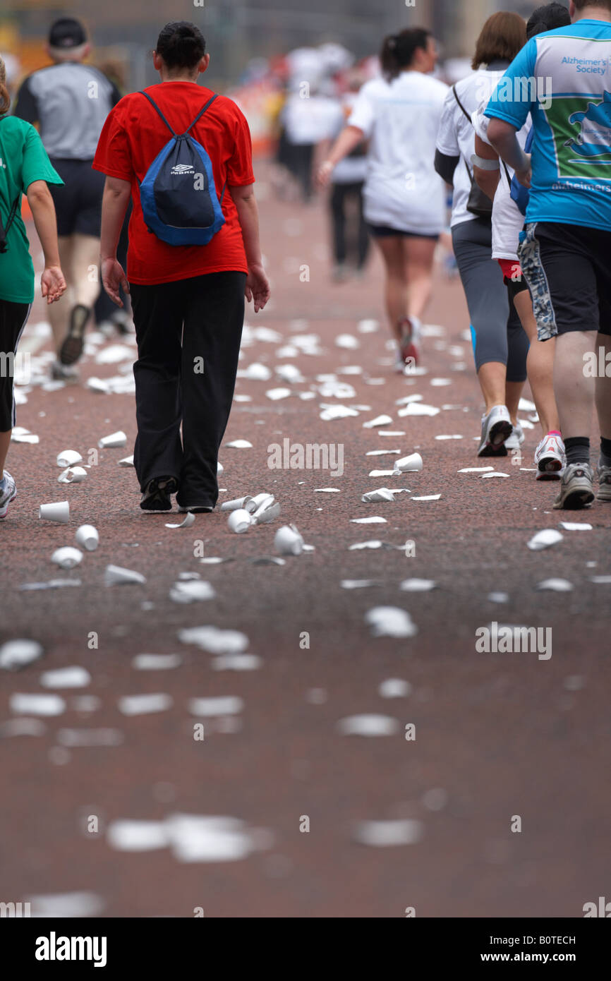 competitors walking home through discarded polystyrene cups litter ...