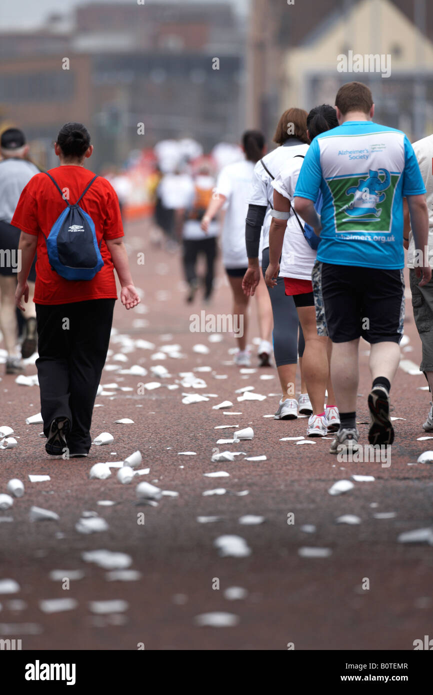 competitors walking home through discarded polystyrene cups litter ...