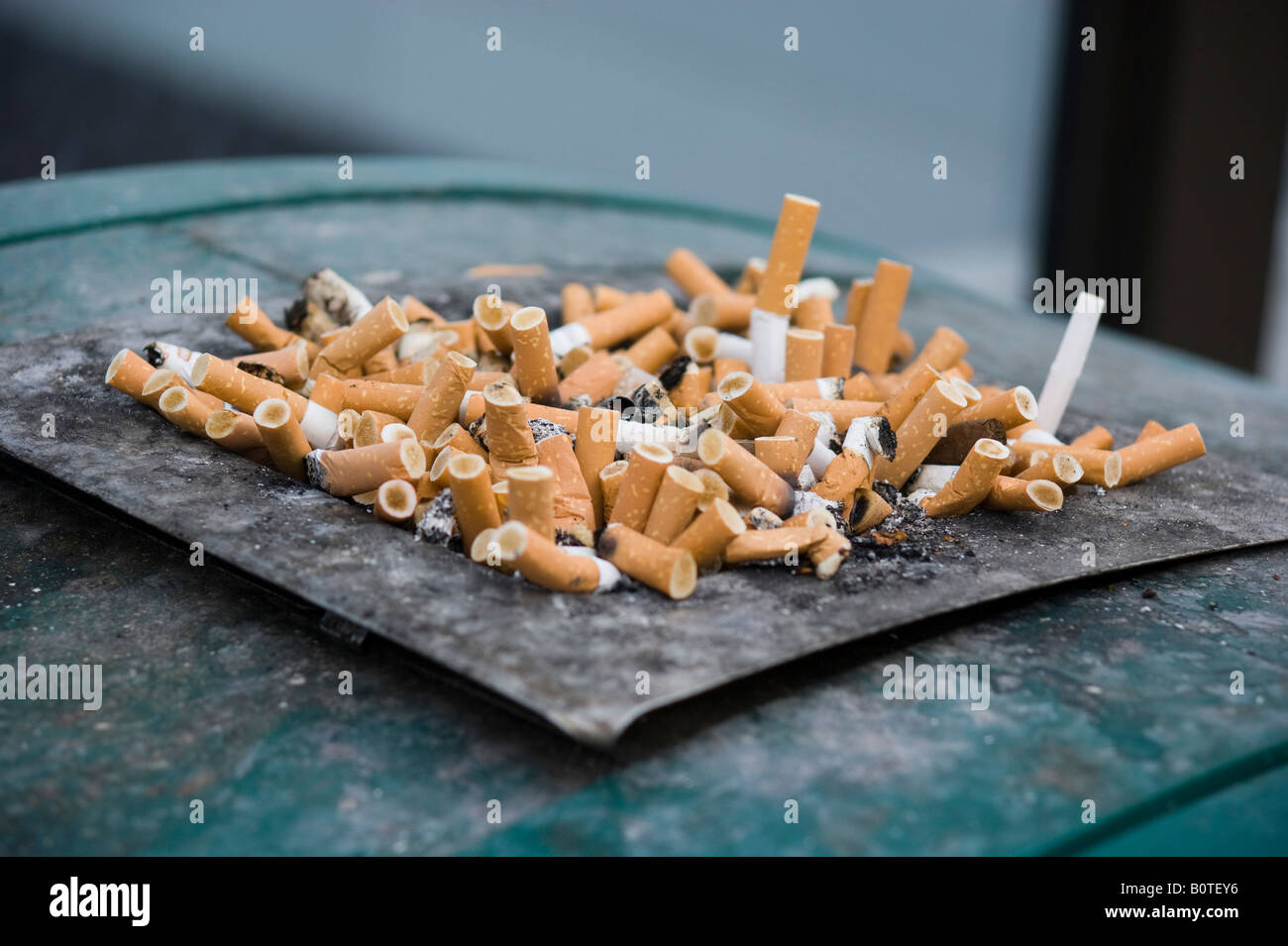 Overflowing outdoor cigarette end bin on the airport viewing terrace no ...