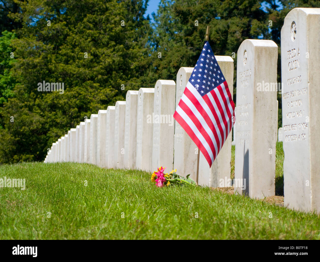 A single US Flag stands by a headstone at the Veterans Memorial ...