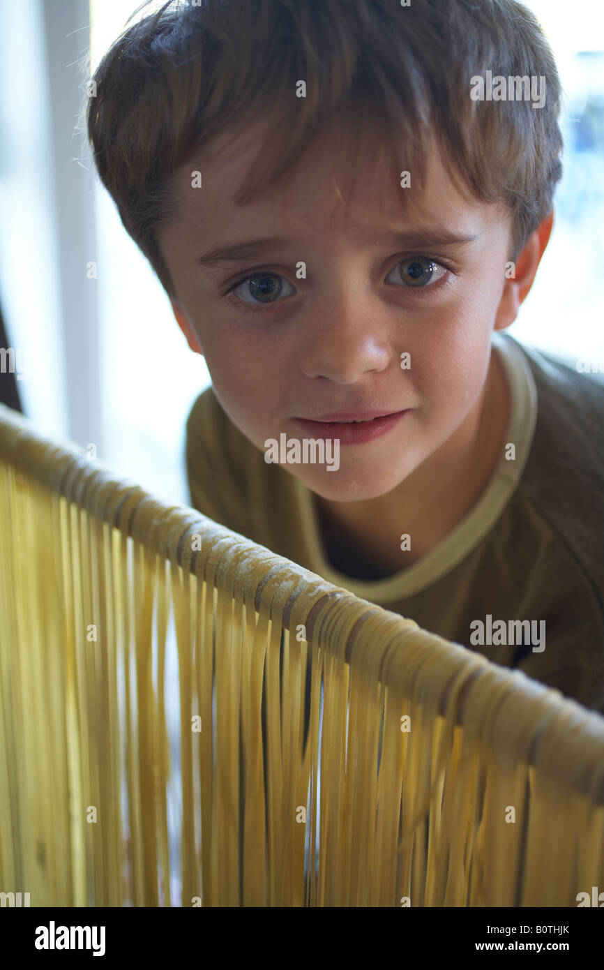 boy child looking over rail draped with freshly made pasta Stock Photo ...