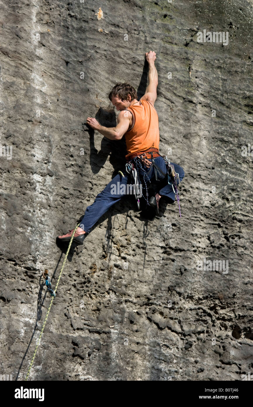 Rock climber climbing a route on Goldstein in the Elbsandsteingebirge ...