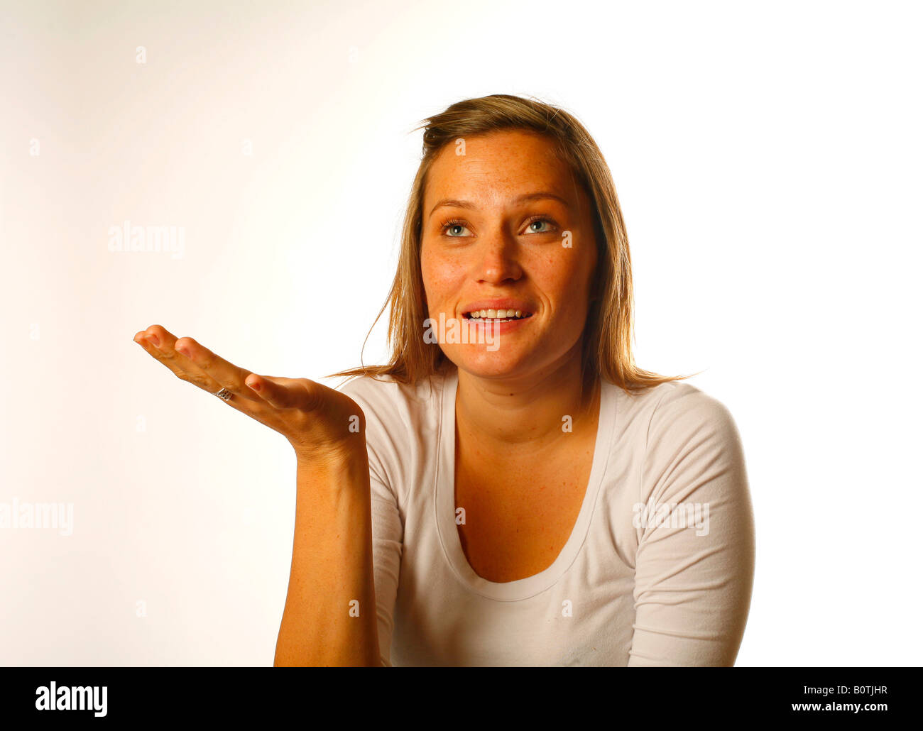 A young woman holds her palm upward in an expression of happy uncaring ...