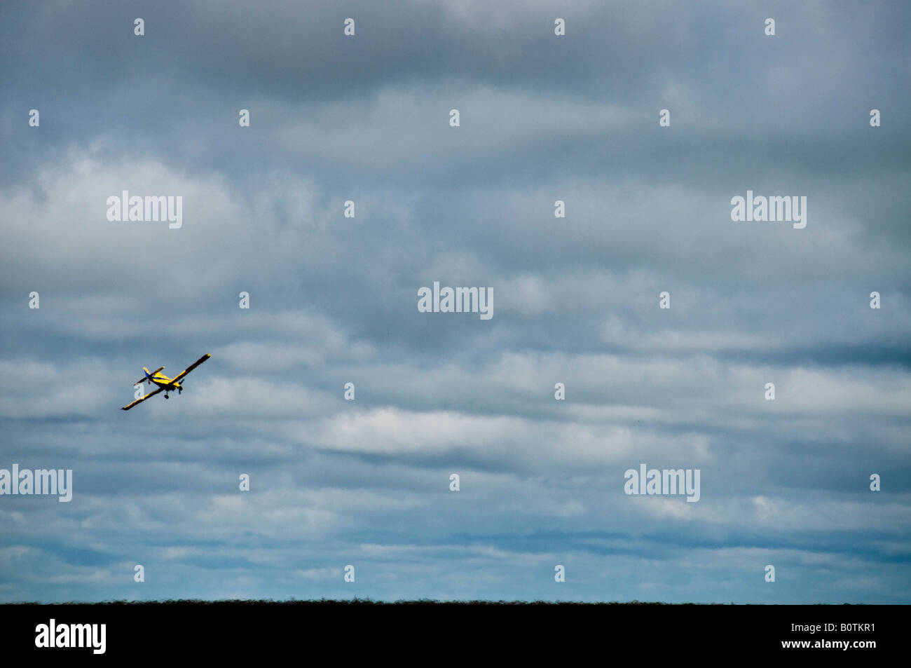 airplane flying sprays pesticide at a soy beans plantation in Brazil ...