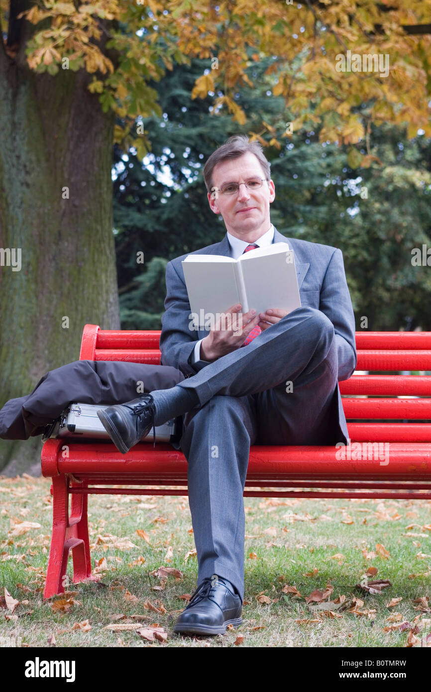 Man on bench reading book hi-res stock photography and images - Alamy