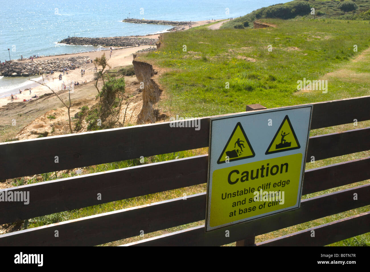 Sign warning of unstable cliff edge with cliff in background looking ...