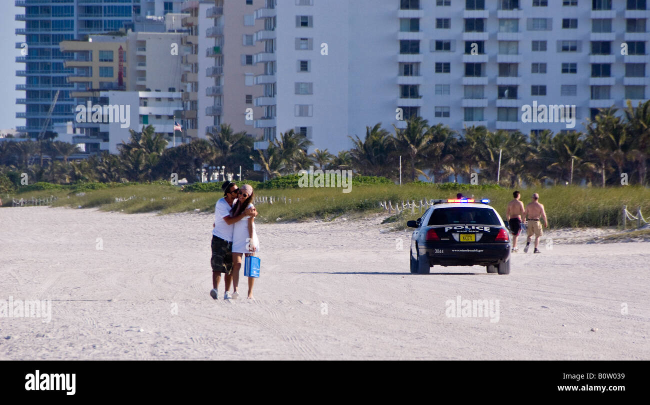 Florida Miami Beach police patrol car on the beach with couple walking ...