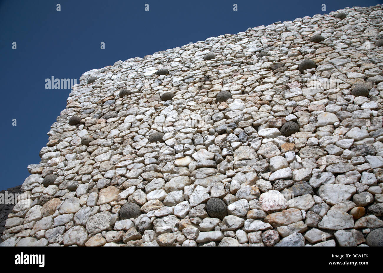 close up of the white quartz facade wall with round granite stones of ...