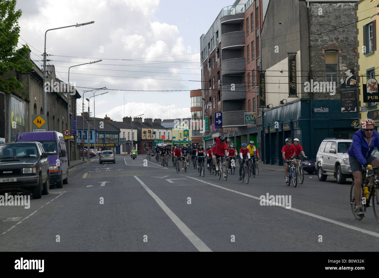 A large group of people bicycling on a street in Limerick Ireland Stock ...