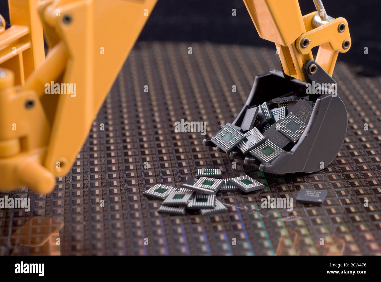 Microchips in the rear bucket of a digger and scattered over a silicon ...