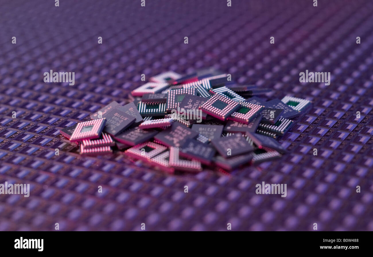 A small pile of microchips on a silicon wafer, lit by blue and red ...