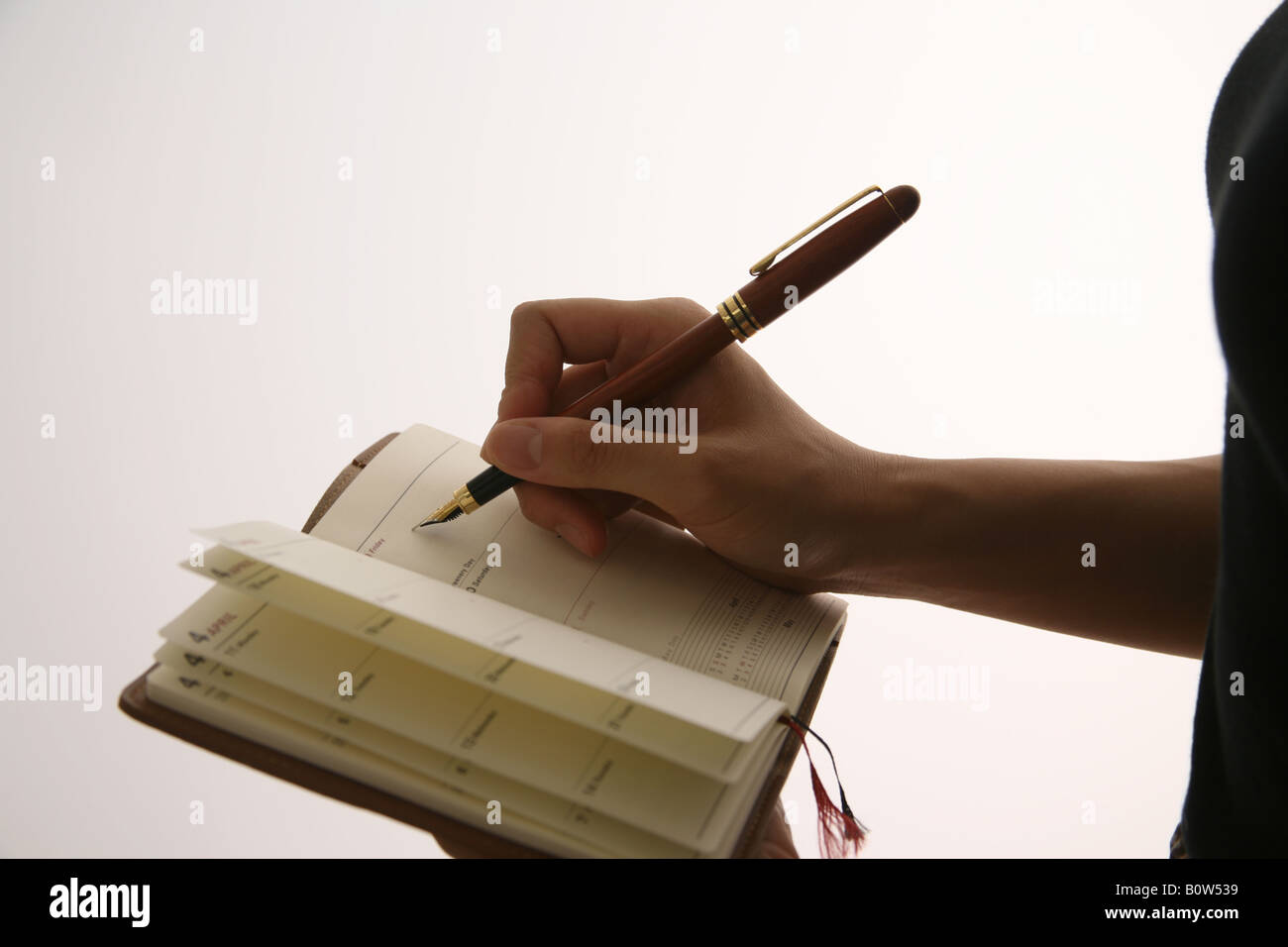 Woman writing in diary Stock Photo - Alamy