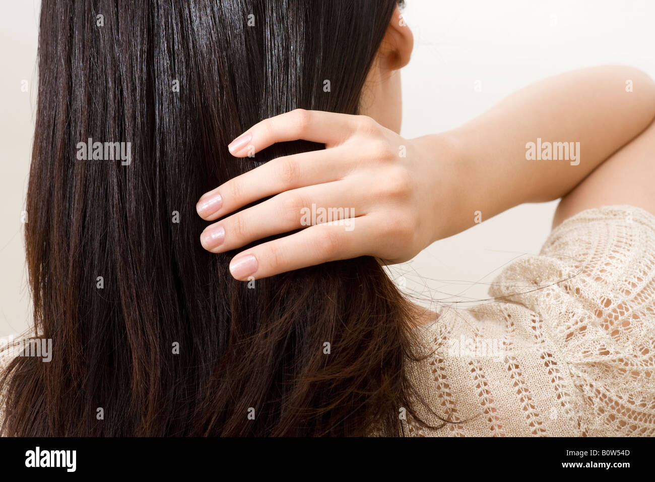 Woman touching her hair Stock Photo - Alamy