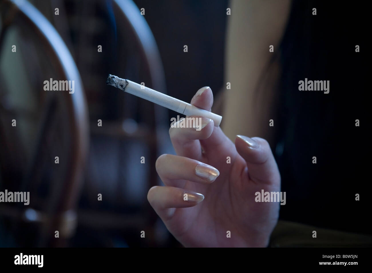 Woman's hand holding lit cigarette Stock Photo - Alamy