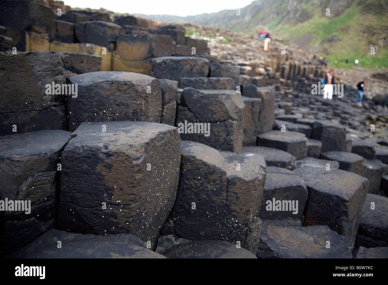 tourists wander round the red basalt hexagonal rock formations at the ...