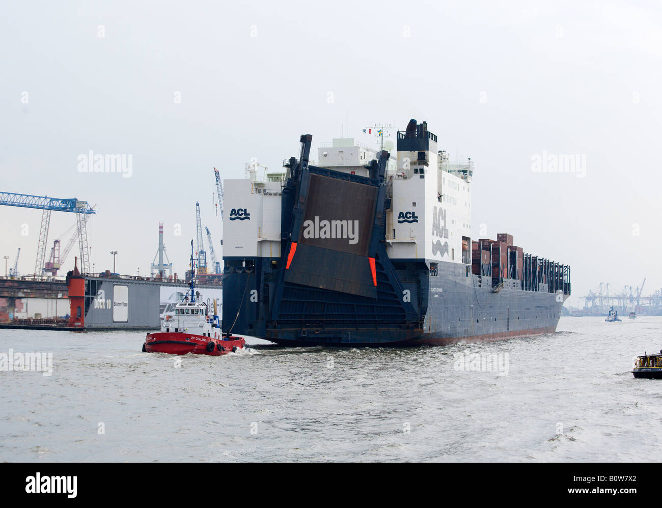 red tug boat behind combined RoRo/Container ship of panmax class ...