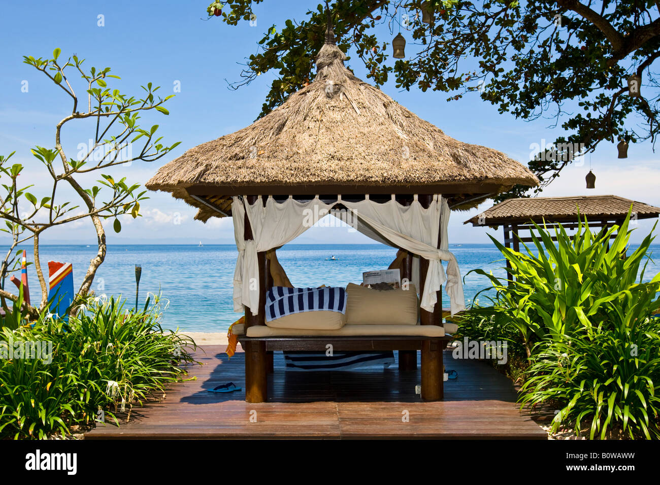 Sunlounger or thatch-roofed deck chair beside the beach of the Sheraton ...