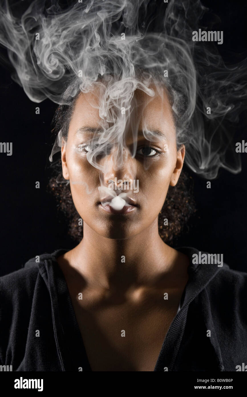 Young, dark-skinned woman smoking a cigarette, cigarette smoke Stock ...