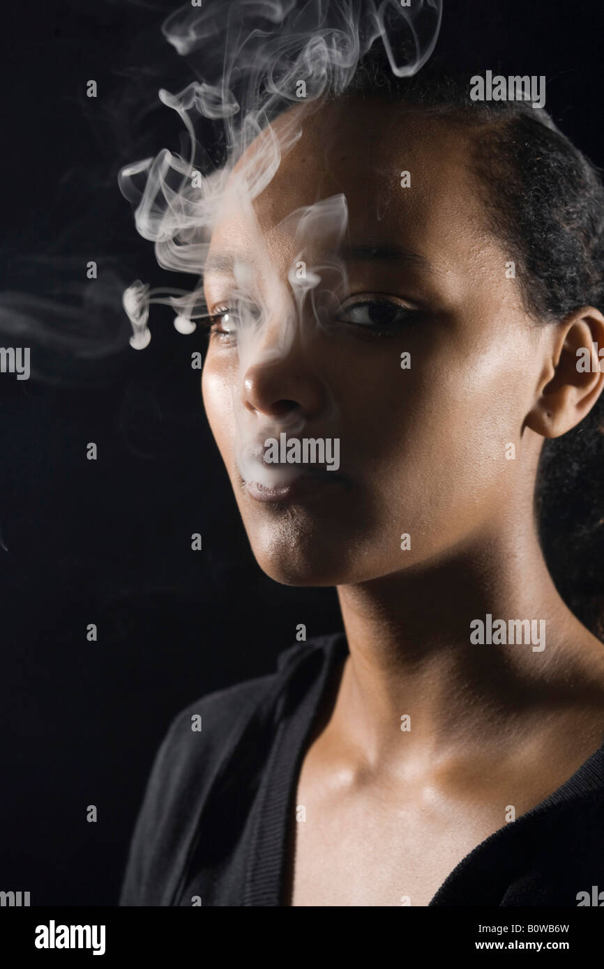 Young, dark-skinned woman smoking a cigarette, cigarette smoke Stock ...