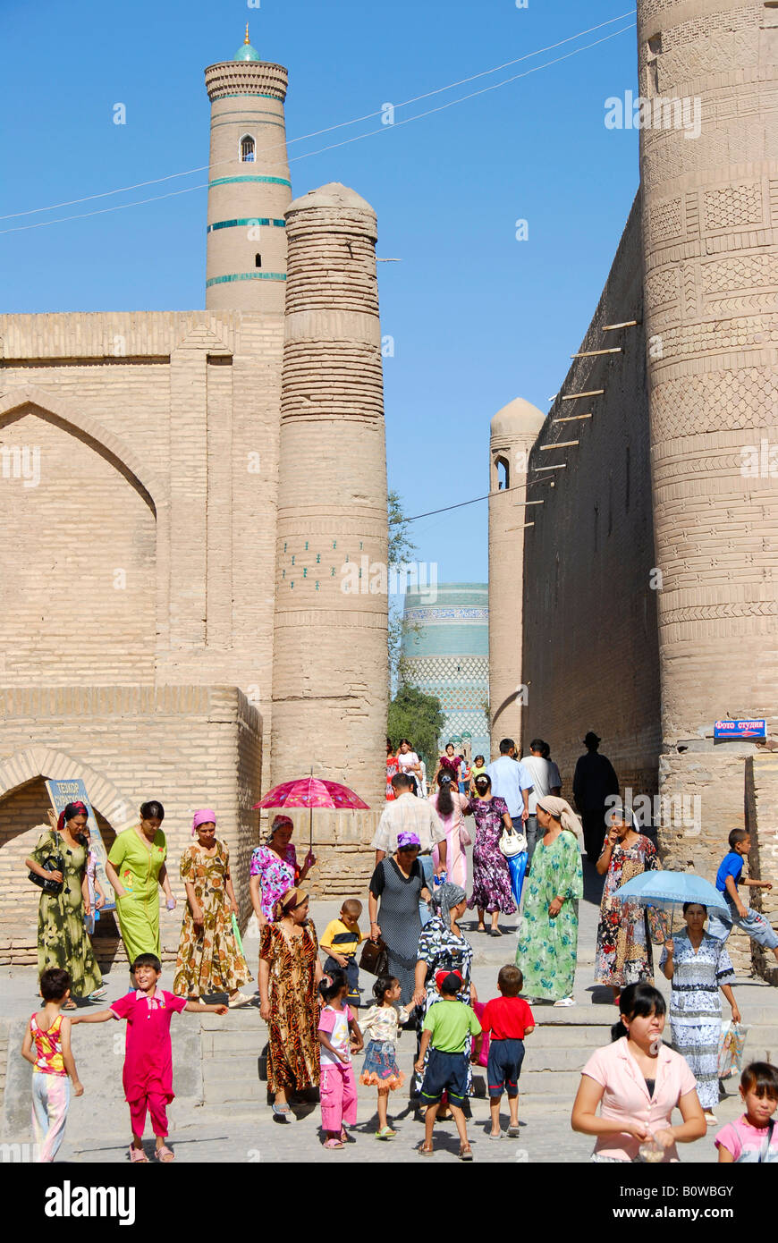 Colourfully dressed people in the historic centre of Chiwa, Uzbekistan ...