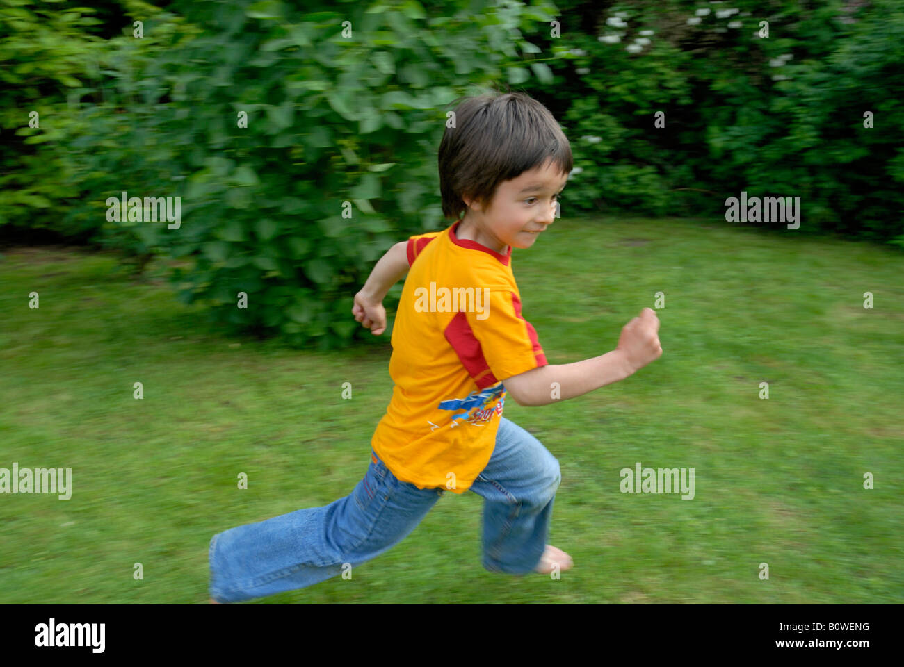 Boy running in the garden Stock Photo - Alamy