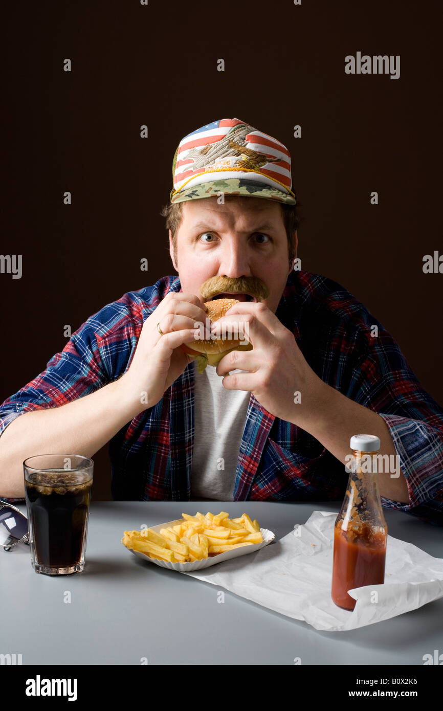 Stereotypical American man eating a burger Stock Photo - Alamy