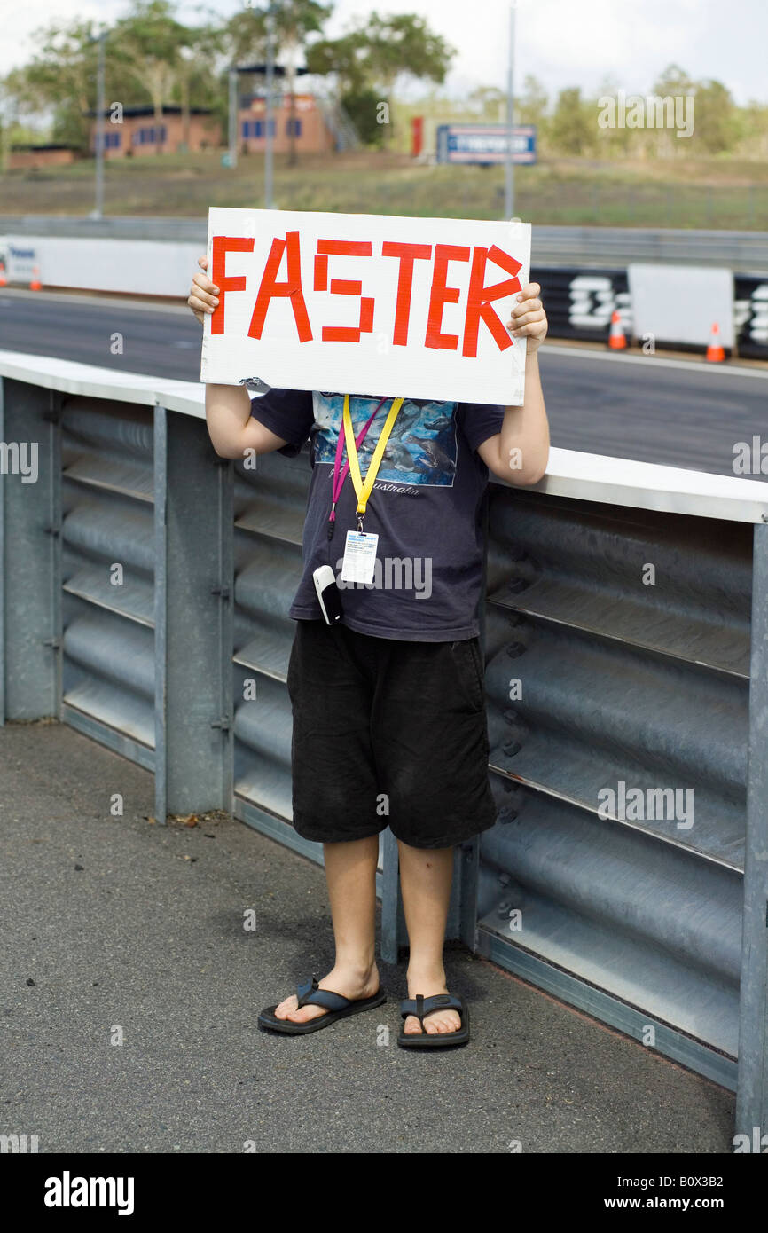 A boy holding a ‘Faster’ sign Stock Photo - Alamy