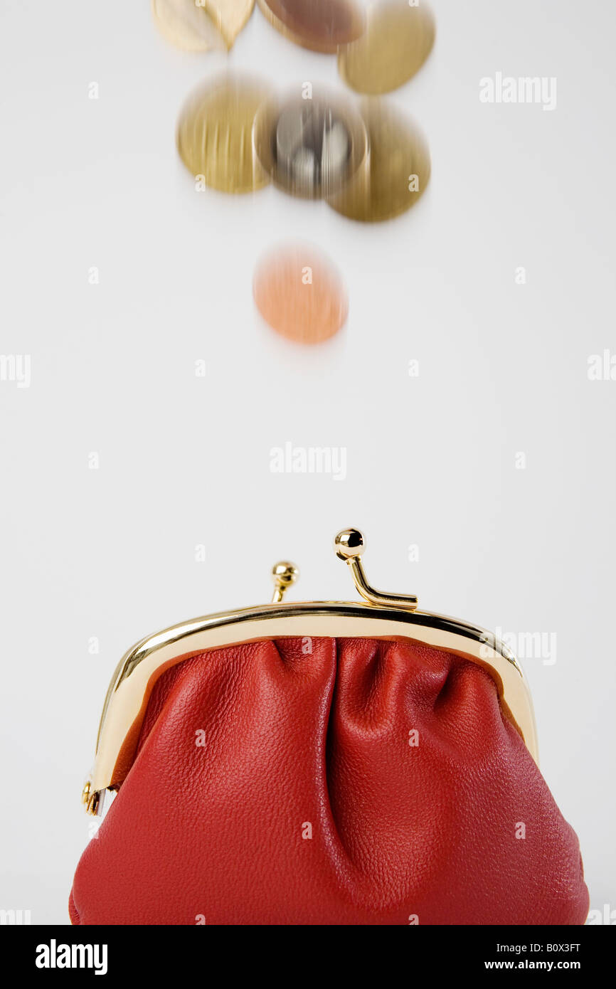 Coins falling into a purse Stock Photo - Alamy