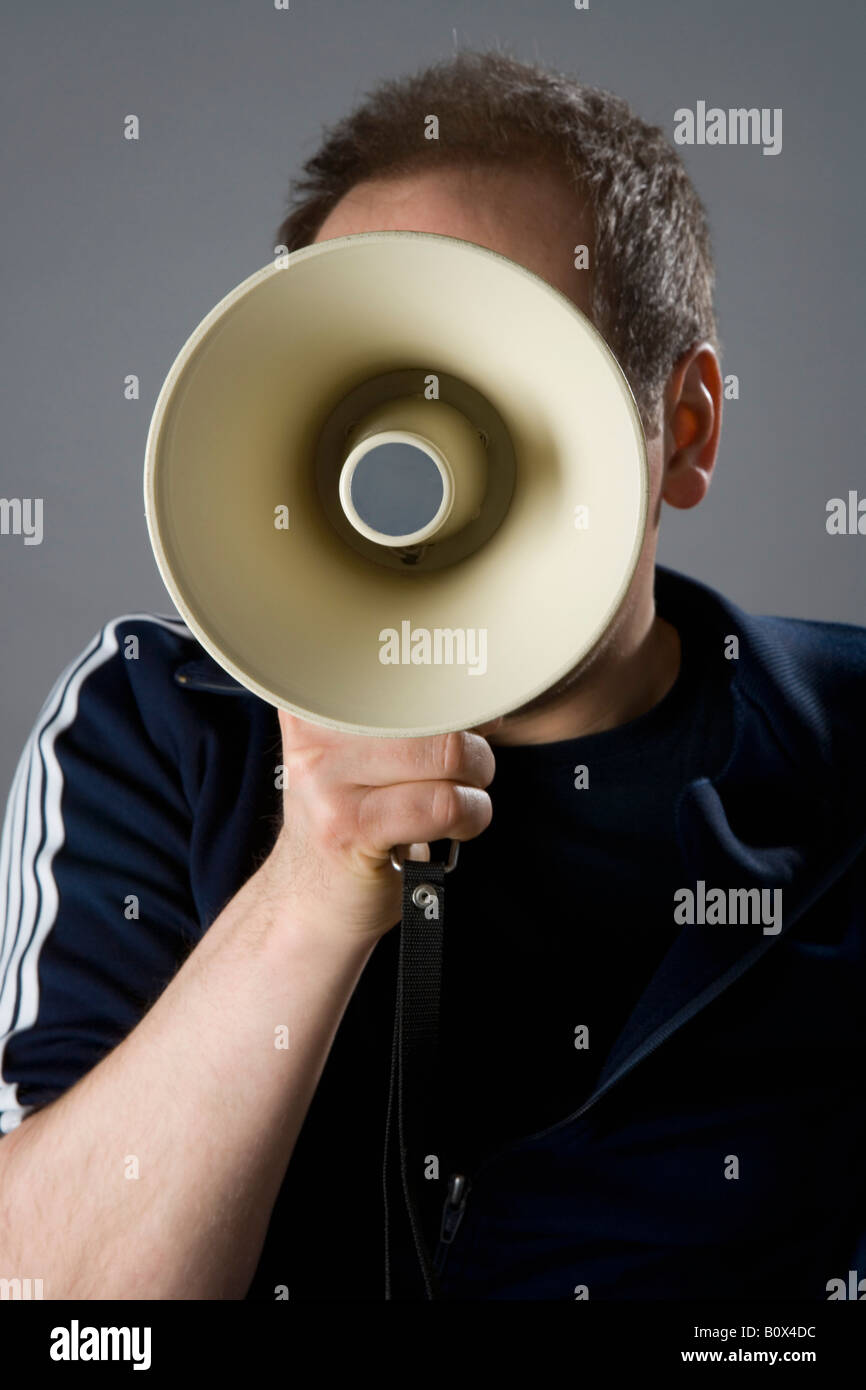 A man holding a megaphone in front of his face Stock Photo - Alamy