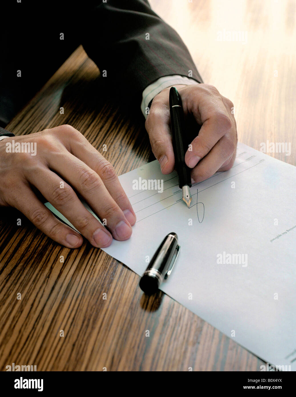 A man signing a document Stock Photo - Alamy