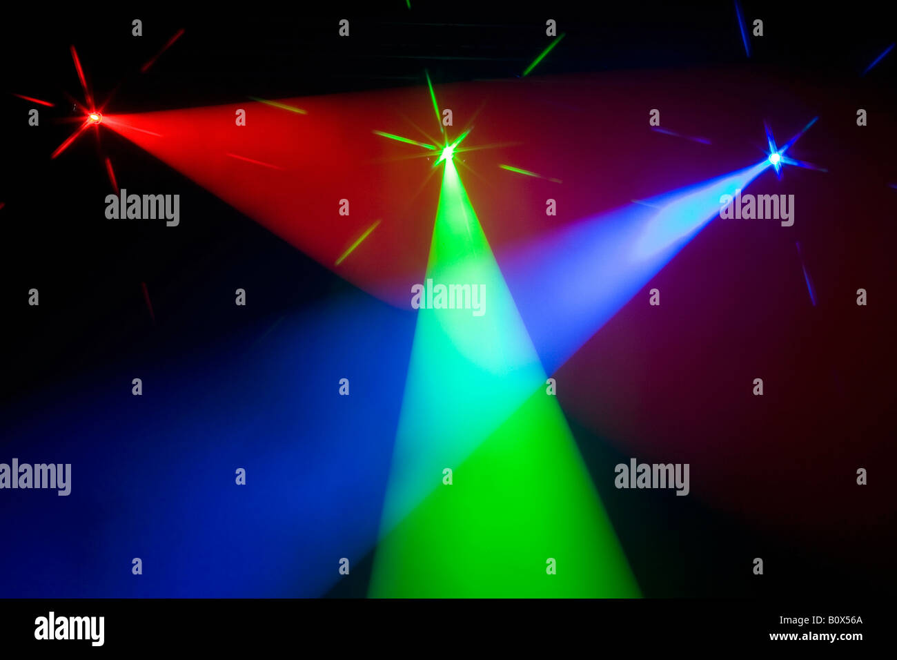 Three multi colored spotlights crossing light beams Stock Photo - Alamy