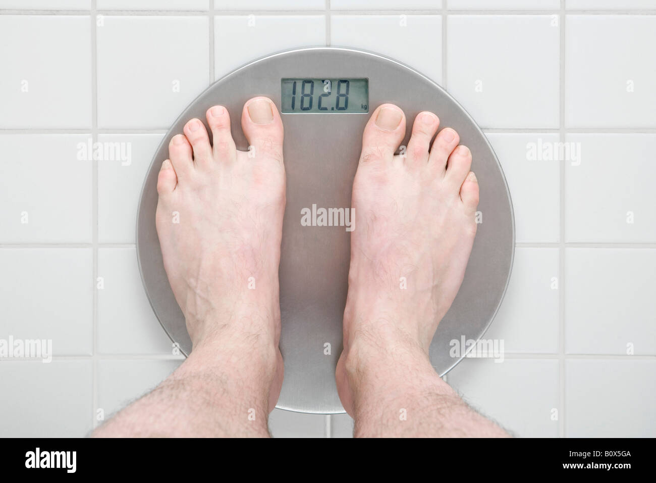 Human feet standing on a scale Stock Photo - Alamy