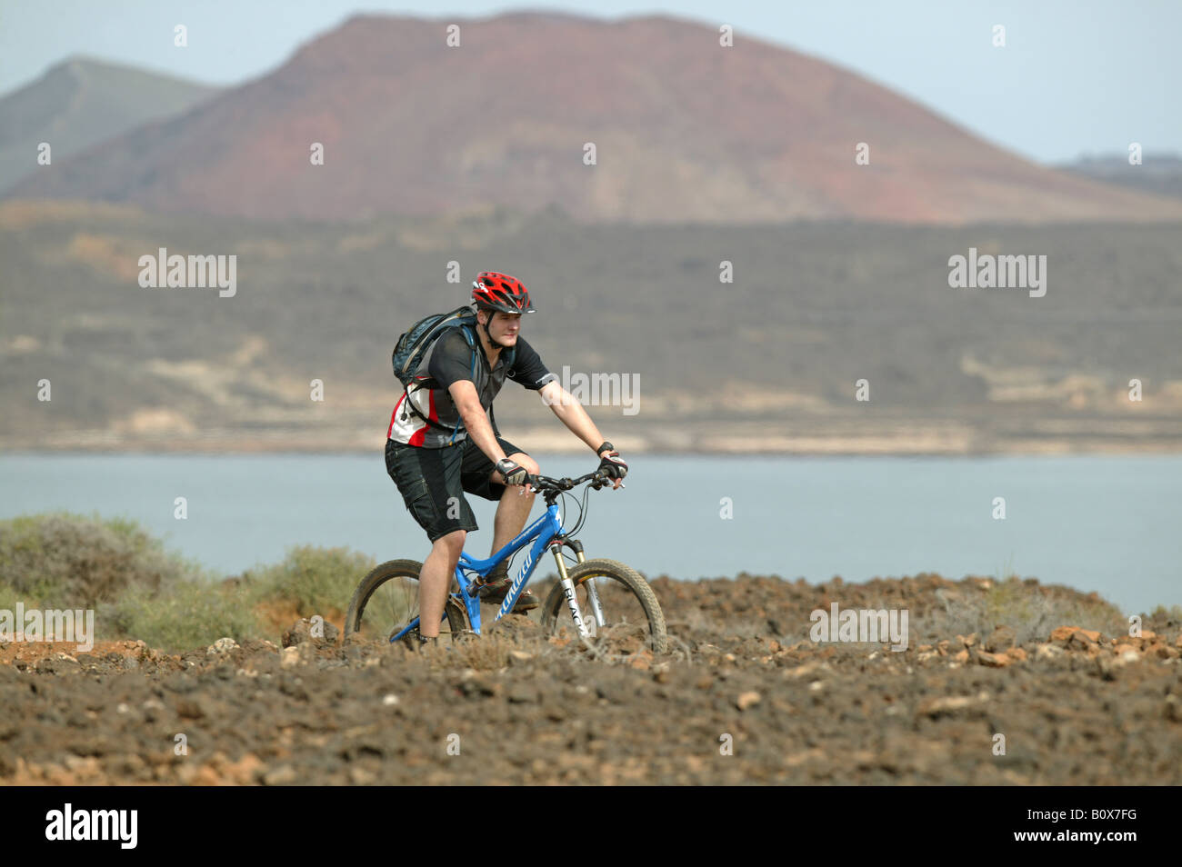 Mountain Biker riding in a rocky landscape by a lake Stock Photo - Alamy