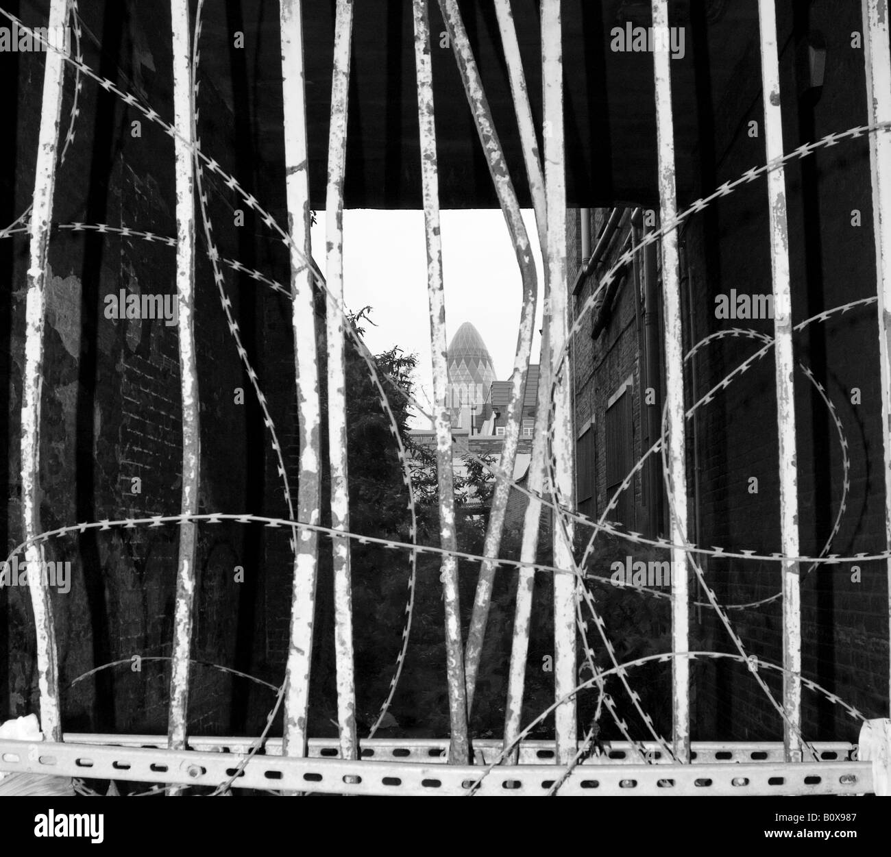 Looking through the bars at the London gherkin Stock Photo - Alamy
