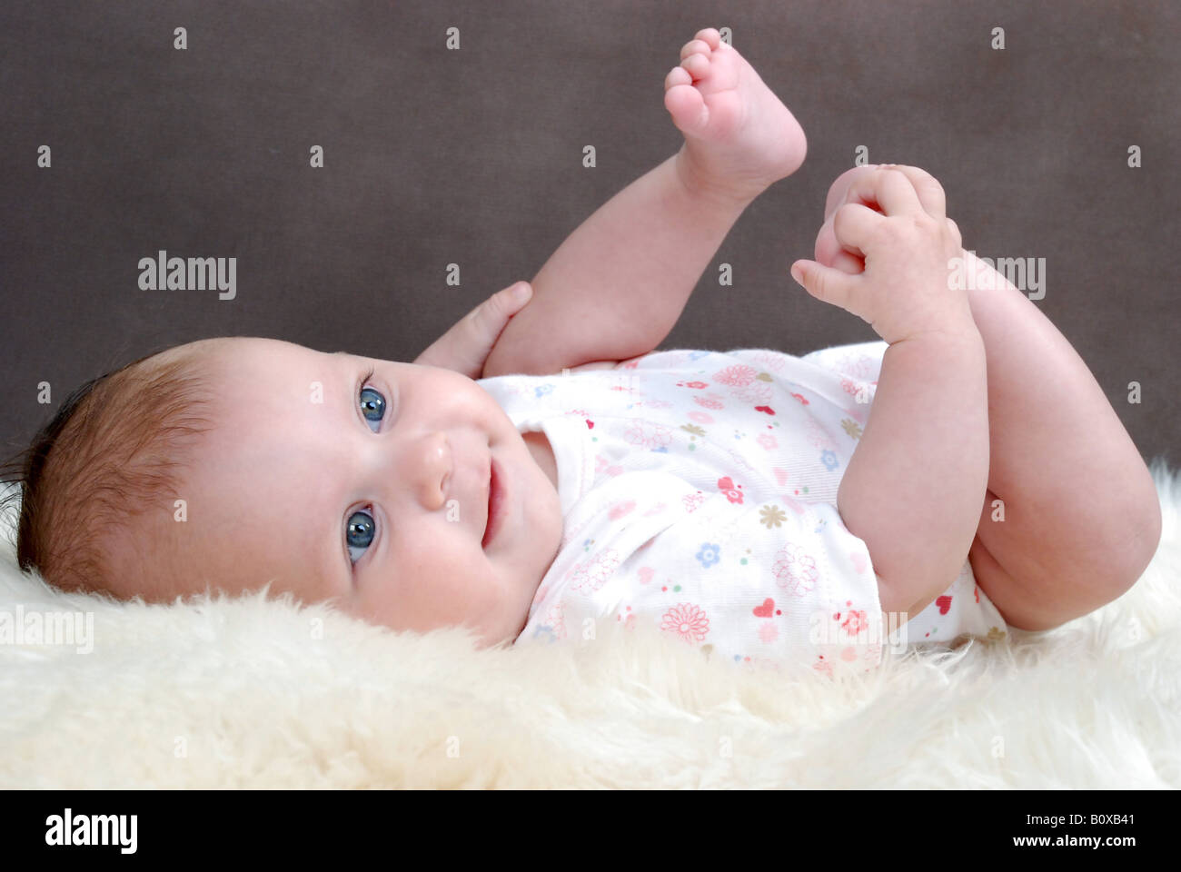 6 month old baby gripping his foot Stock Photo - Alamy