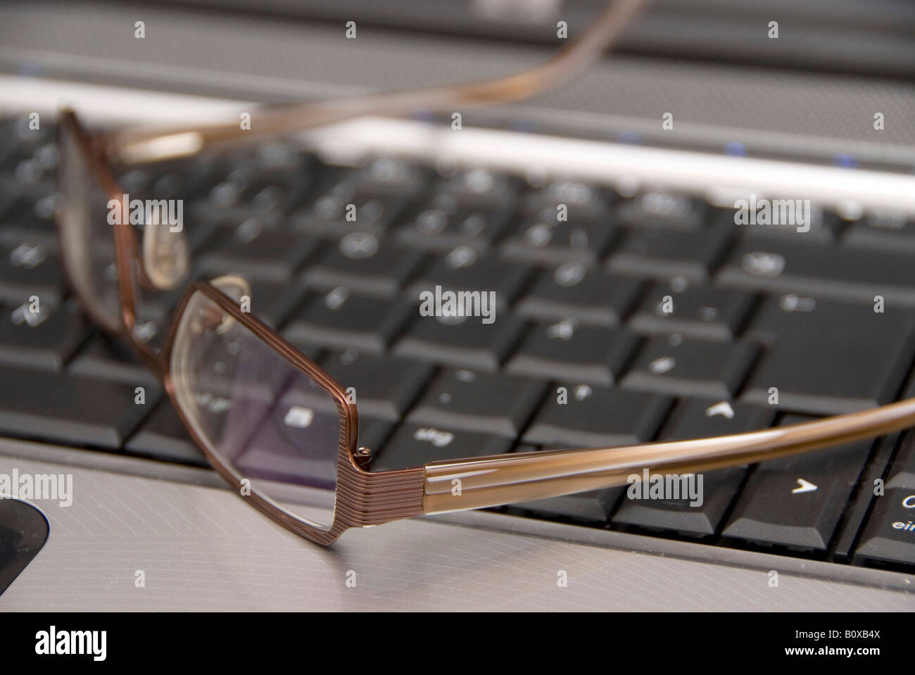 glasses on computer keyboard Stock Photo - Alamy