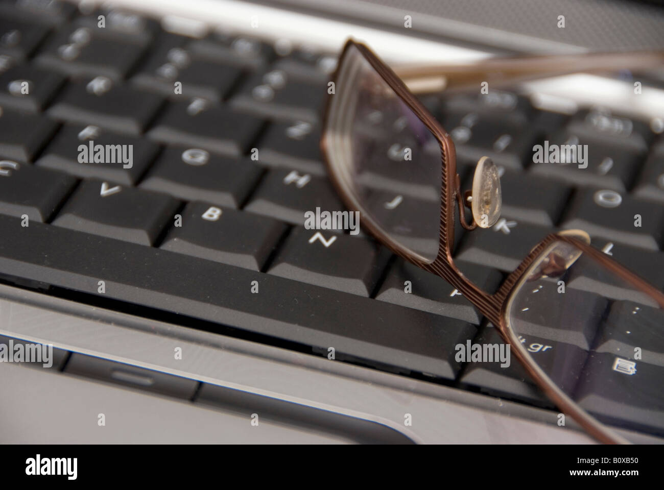 glasses on computer keyboard Stock Photo - Alamy