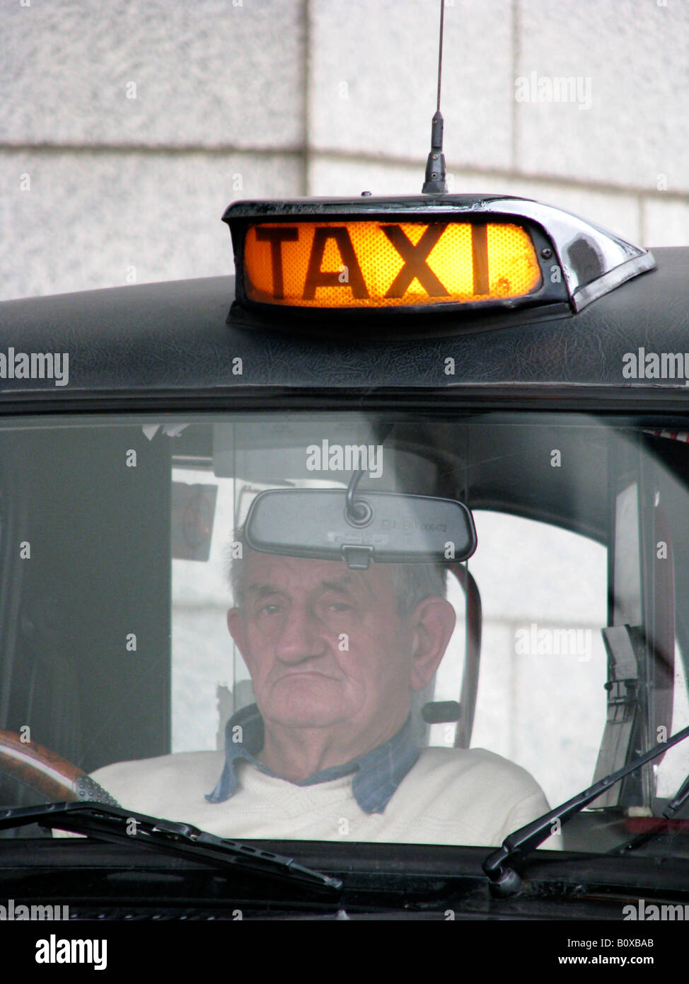Old black English taxi with illuminated figures - driver waiting for ...