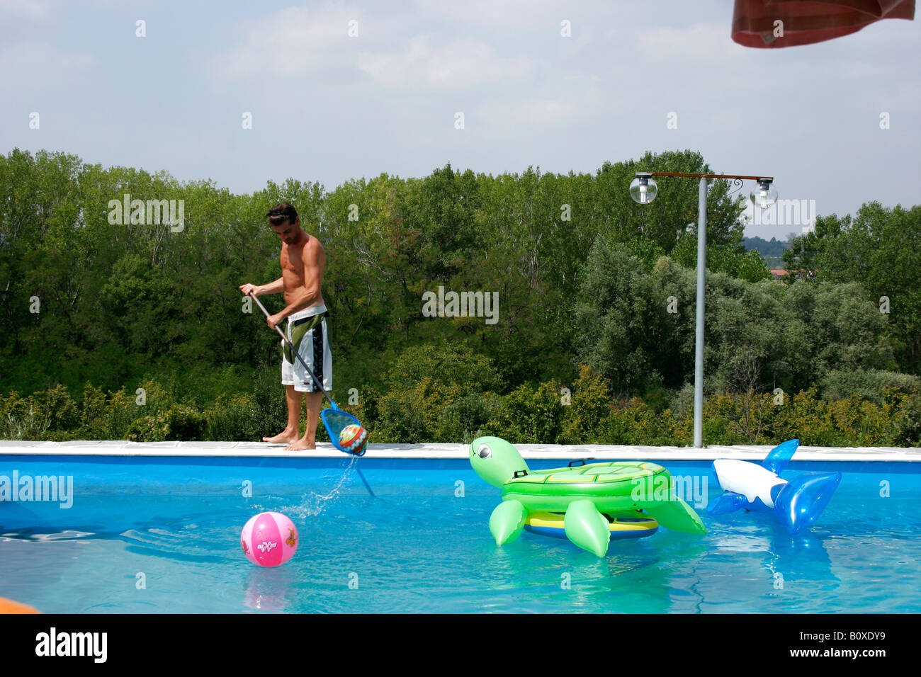 Young man cleaning swimming pool hi-res stock photography and images ...