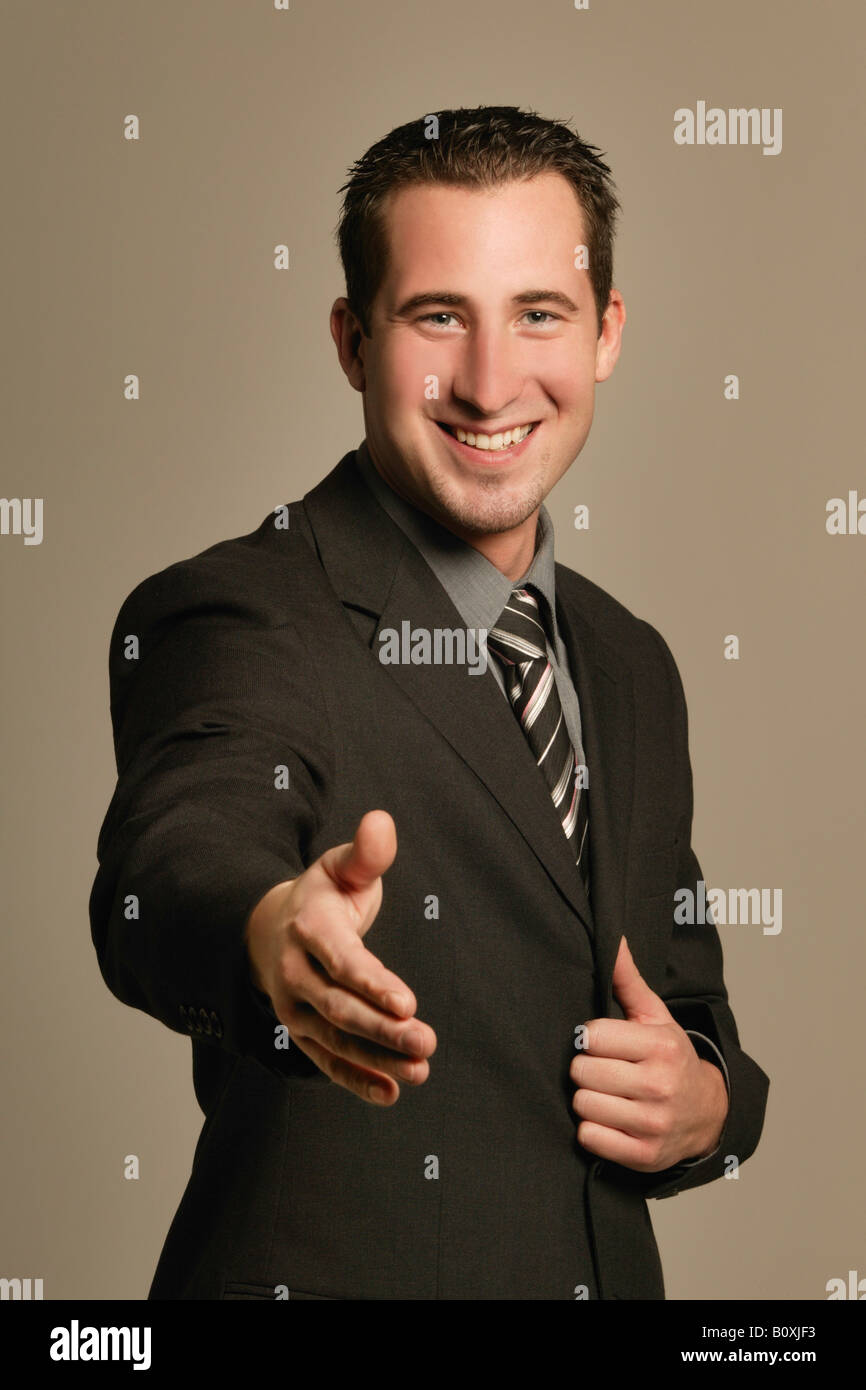 Businessman with hand extended Stock Photo - Alamy