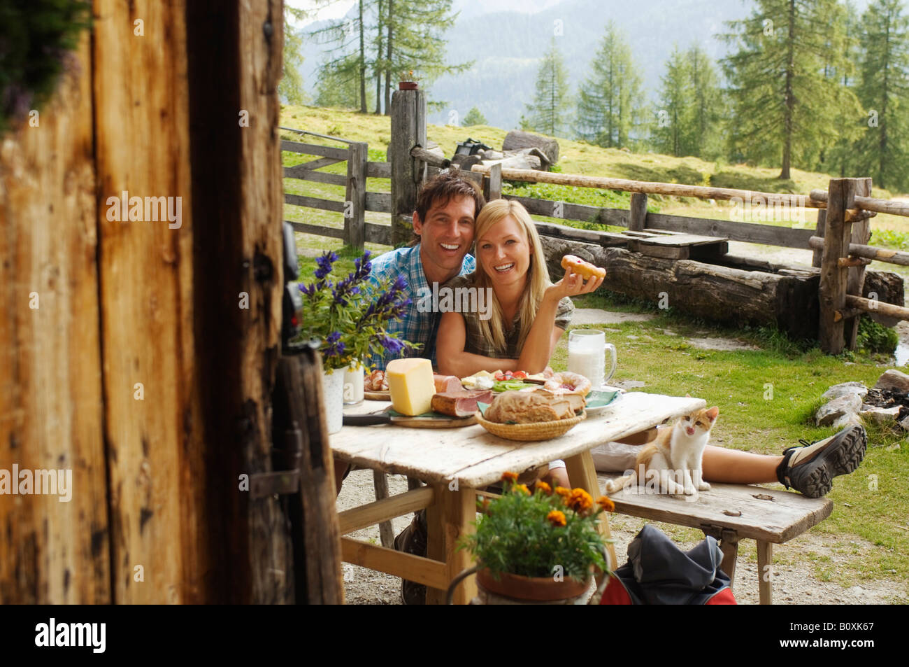 Austria, Salzburger Land, couple having breakfast in front of hut Stock ...