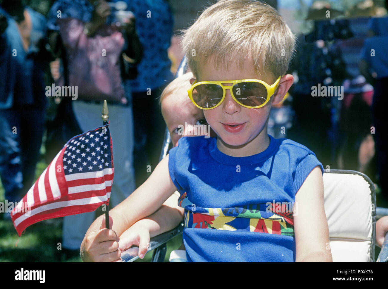 A young boy and his sister in a carriage watch the 4th of July parade ...