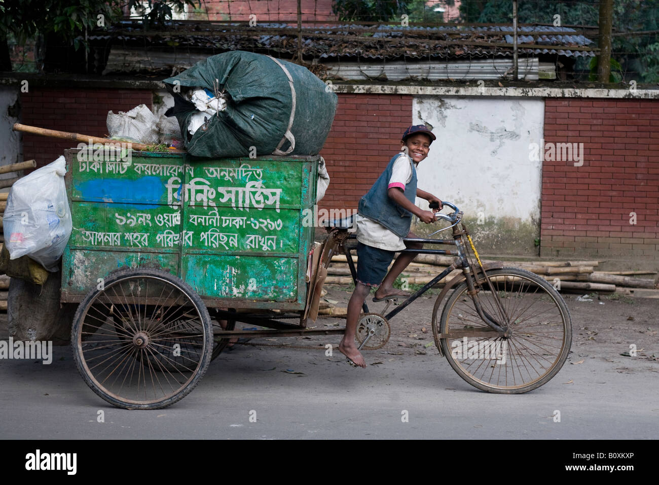 A young boy pedals a rickshaw full of garbage in Dhaka Stock Photo - Alamy