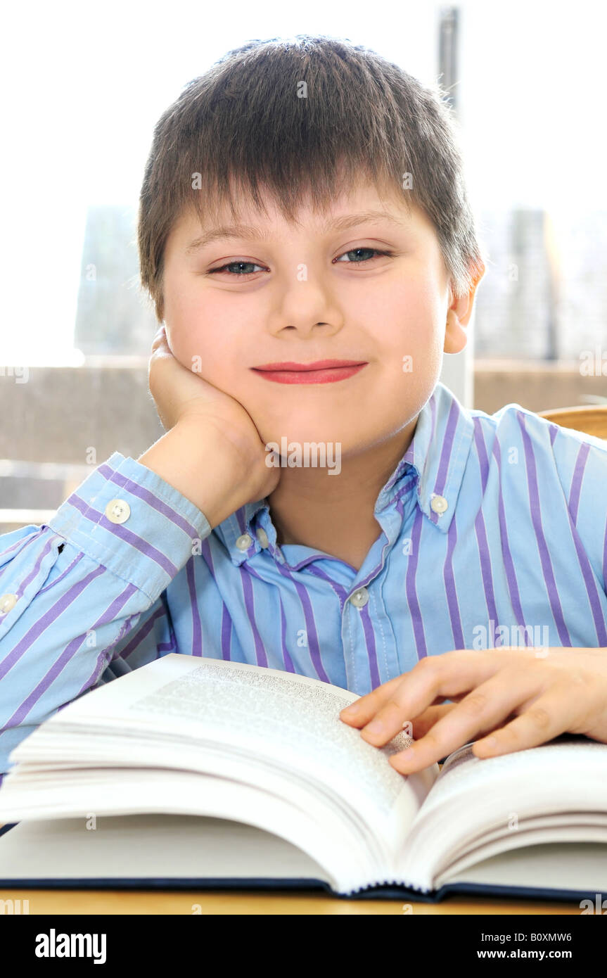 Happy school boy studying with a book Stock Photo - Alamy